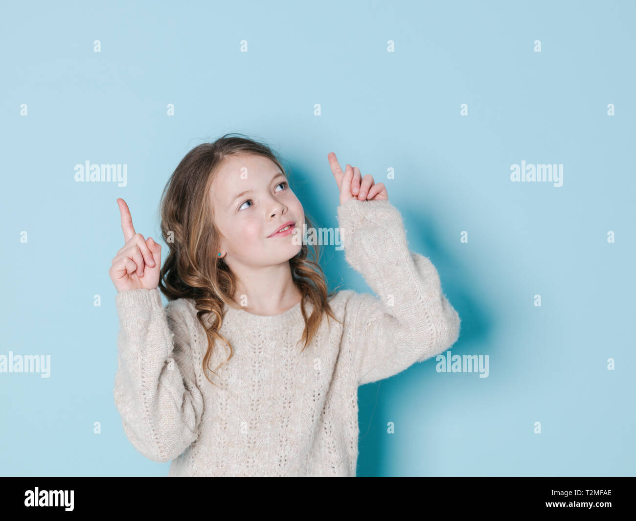 pretty and cool 9 year old girl with brown wool sweater posing in front ...