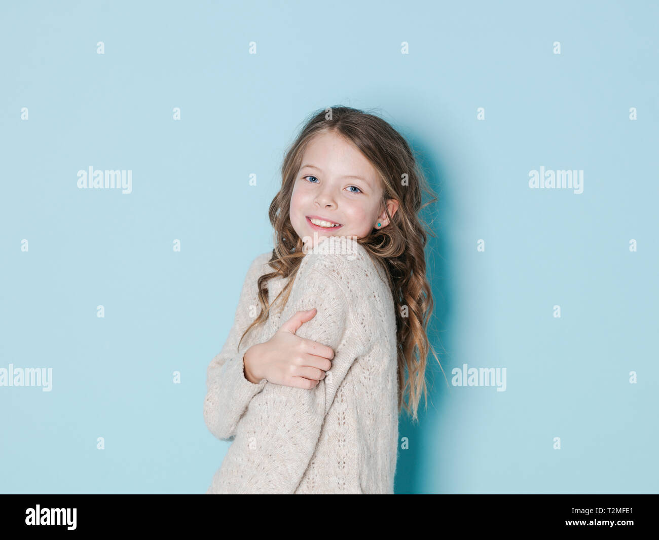 pretty and cool 9 year old girl with brown wool sweater posing in front ...