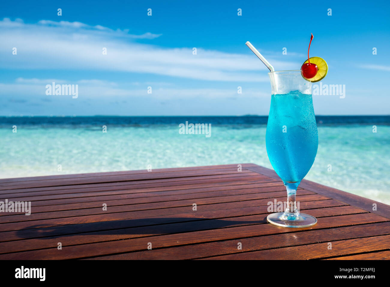 Blue lagoon cocktail on table and beautiful sea background Stock Photo ...
