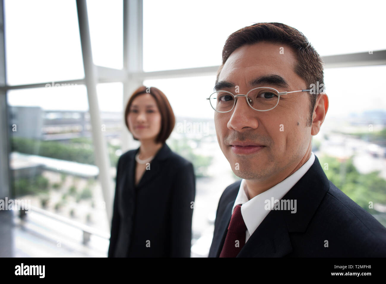 Portrait of Chinese businessman with his colleague in the background ...