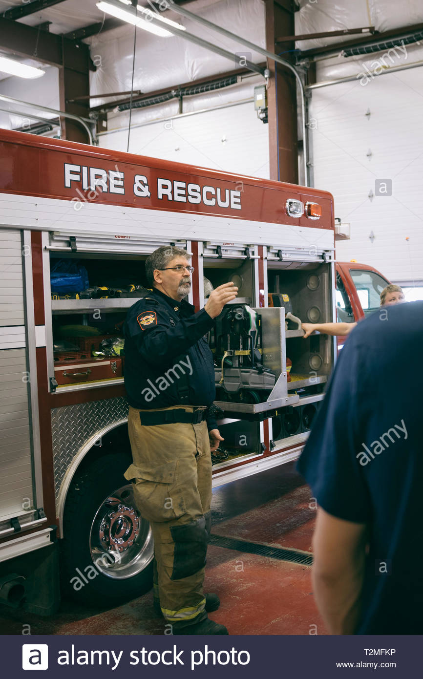 Firefighter leading meeting at fire engine Stock Photo - Alamy