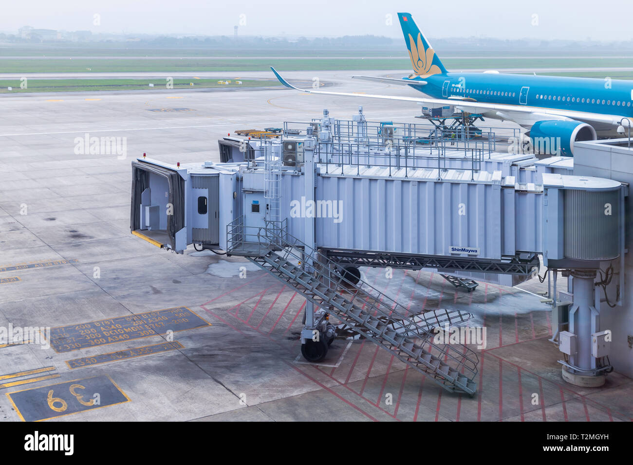 Boarding bridge or jet bridge on prepare by ground service crew for ...