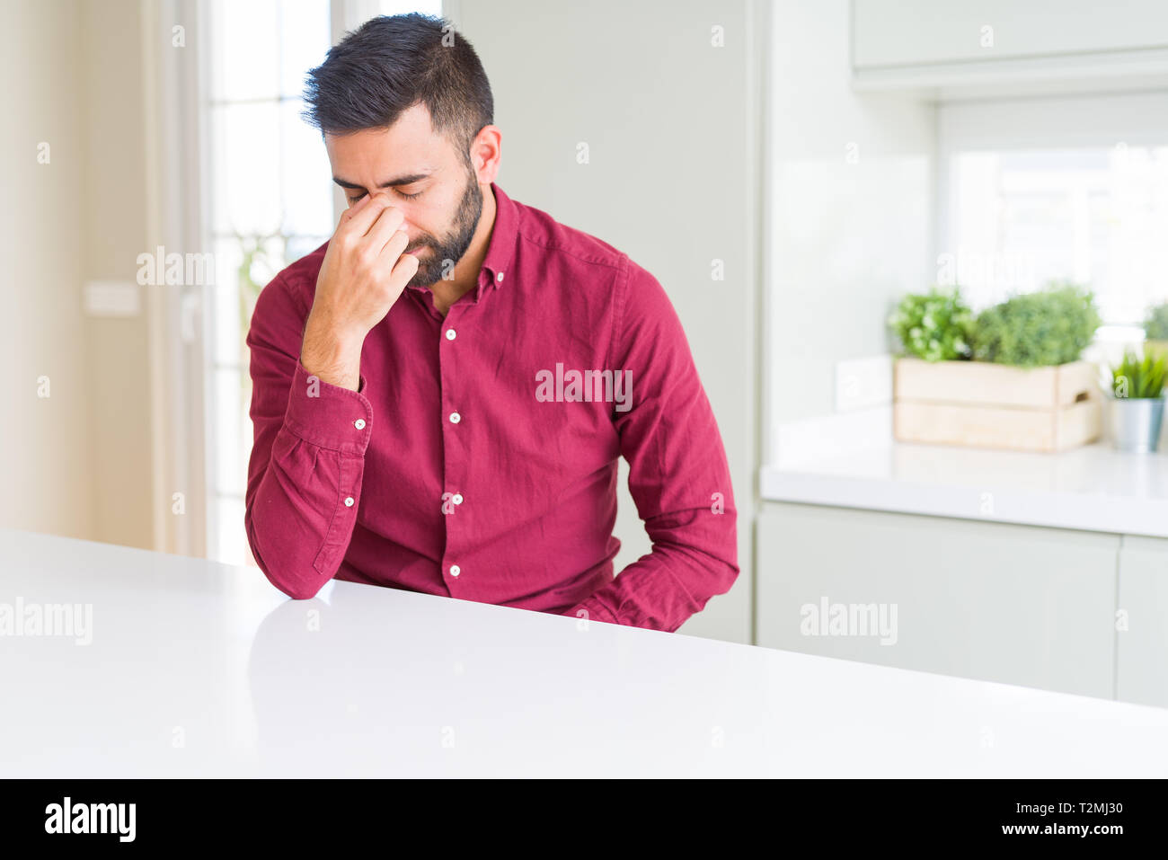 Handsome hispanic business man tired rubbing nose and eyes feeling ...