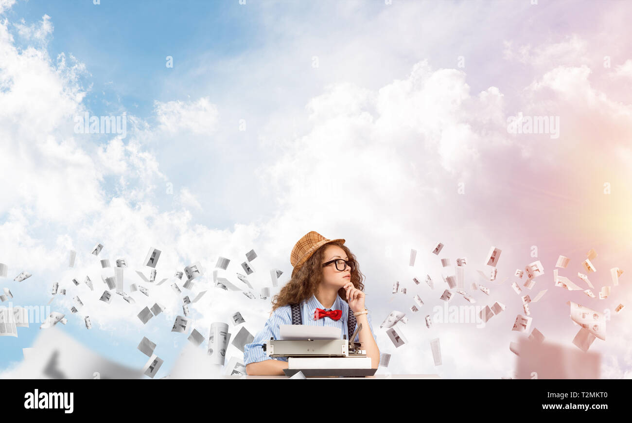 Young and beautiful woman writer in hat and eyeglasses using typing ...