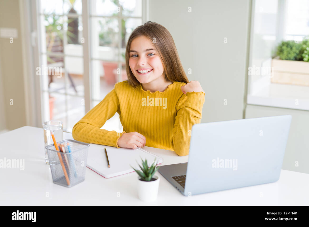 Beautiful young girl studying for school using computer laptop with a ...