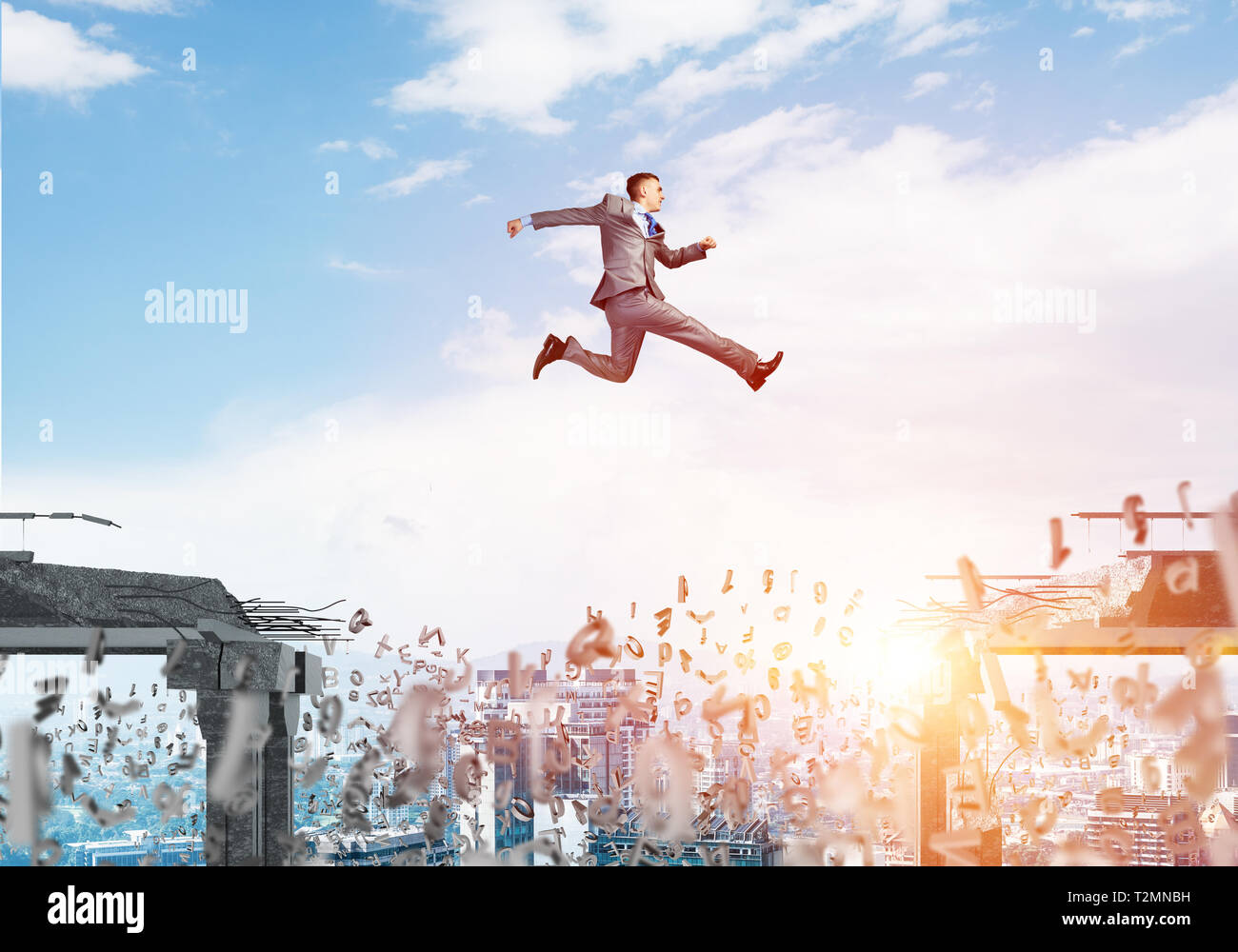 Businessman jumping over gap with flying letters in concrete bridge as ...