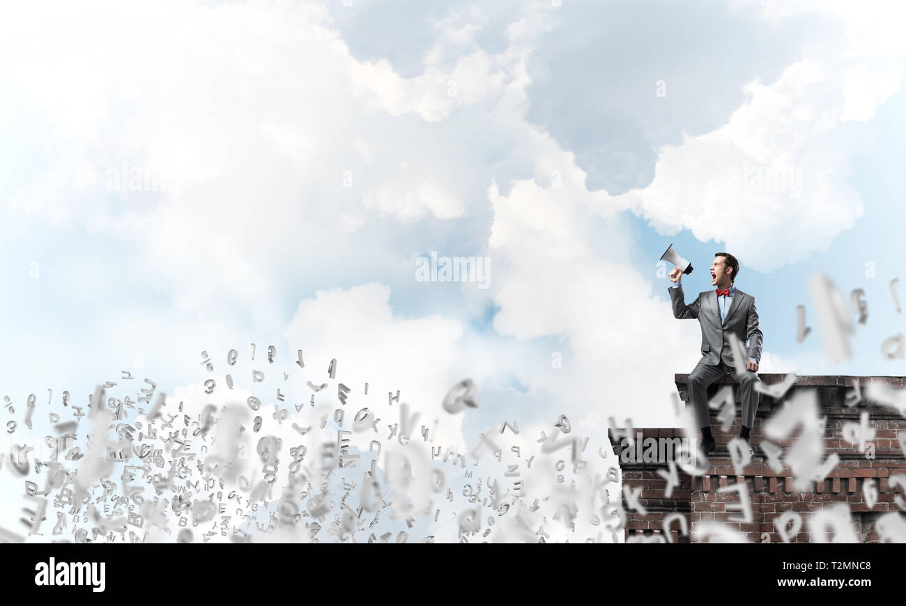 Young businessman sitting on bench and screaming emotionally in ...