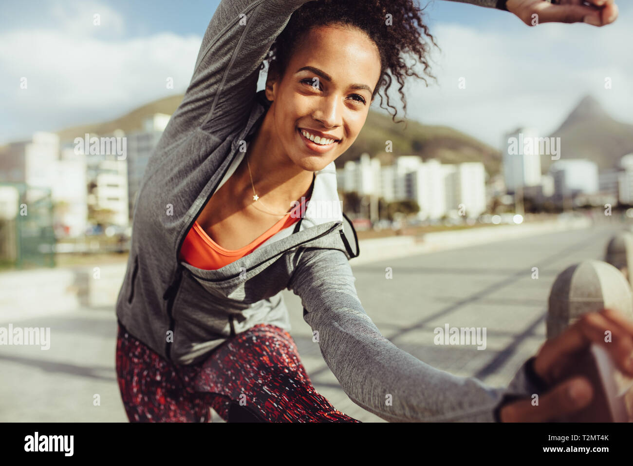 Fitness female doing leg stretches outdoors. Woman athlete working out ...