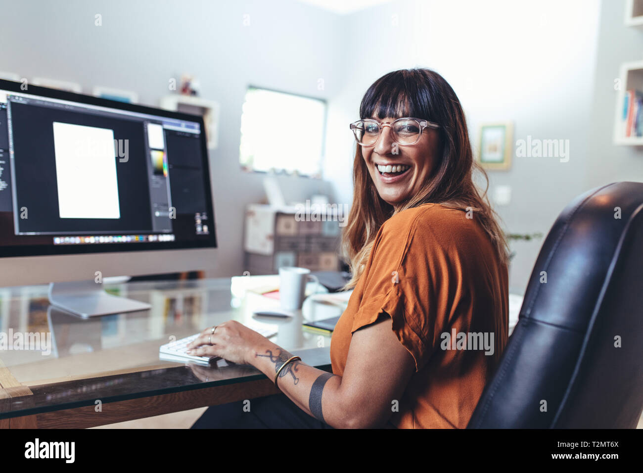 Side view of a creative artist working on her designs on a computer ...