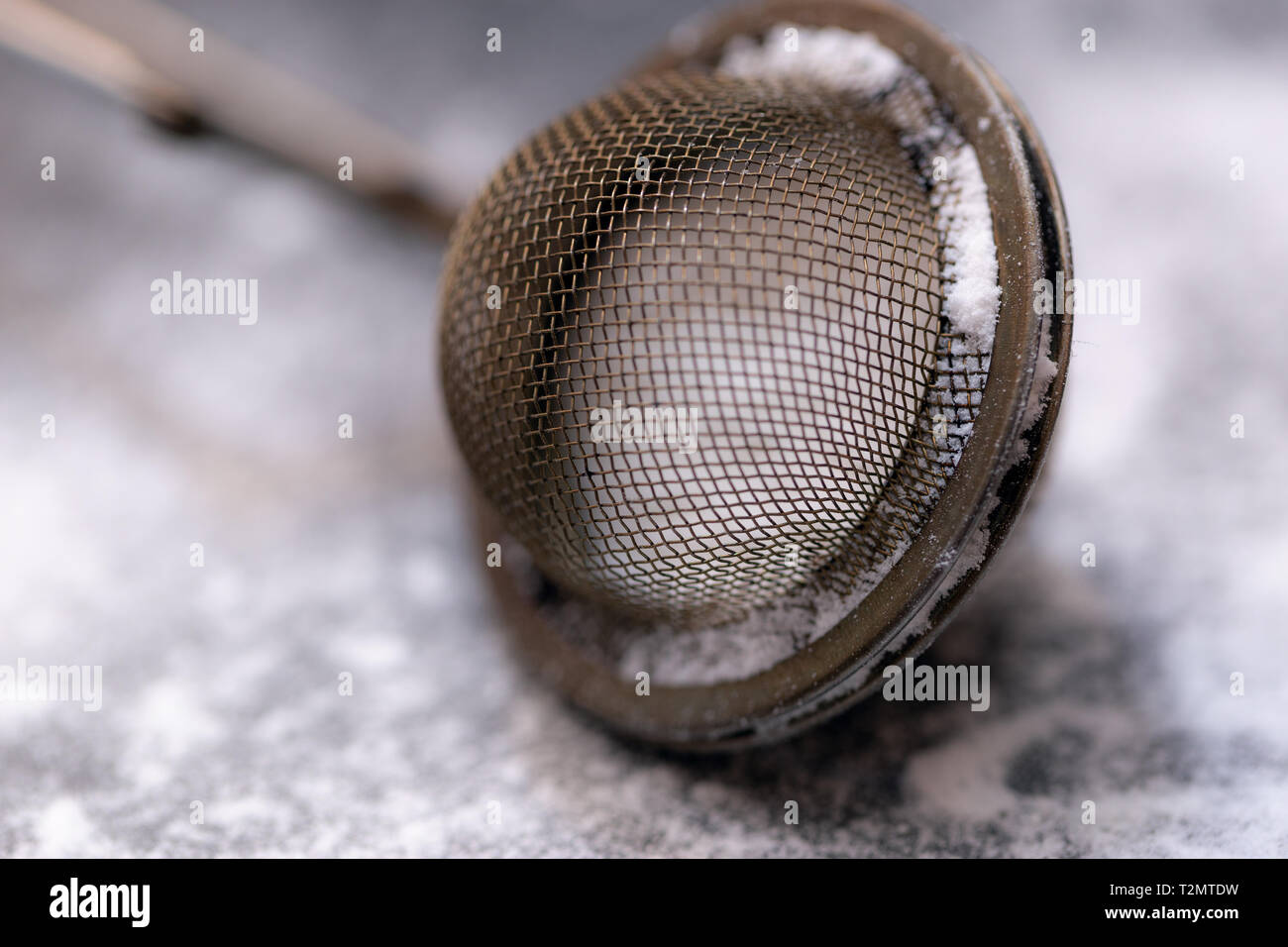 Powdered sugar in a sieve, close up Stock Photo - Alamy