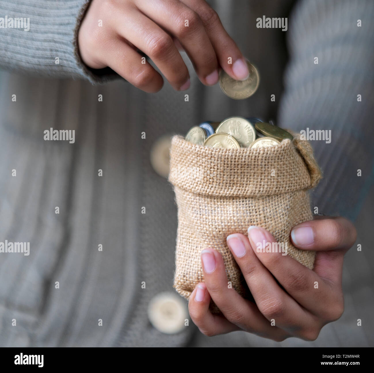 Saving money or coins in a sack holding in a young female hand for ...