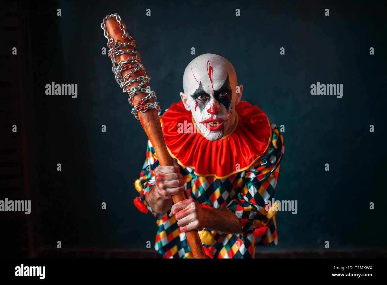 Mad bloody clown with baseball bat. Man with makeup in halloween ...