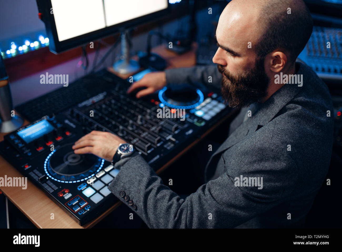 Male sound editor at remote control panel in the recording studio ...