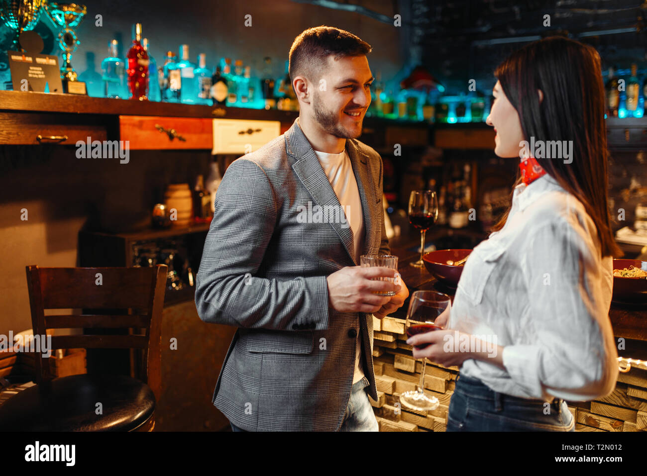 Love couple with alcoholic beverages talking at bar counter, romantic ...