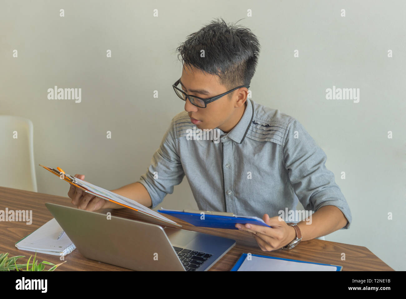 Young Asian manager reading reports in the office Stock Photo - Alamy