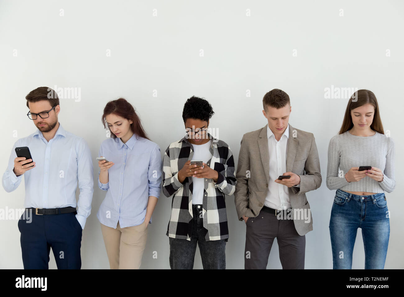 Group of students or businesspeople standing in a row opposite white ...