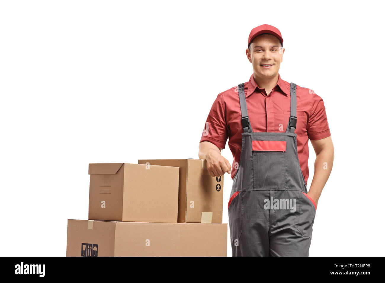 Delivery man leaning on a stack of boxes loaded on a hand truck ...