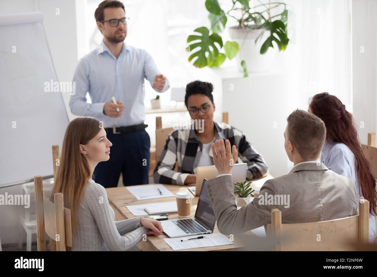 Young man raising hand to ask question, boss leader businessman ...