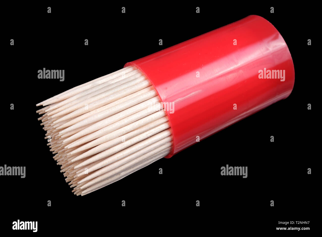 Wooden sharp toothpicks in red plastic container. Isolated on black ...