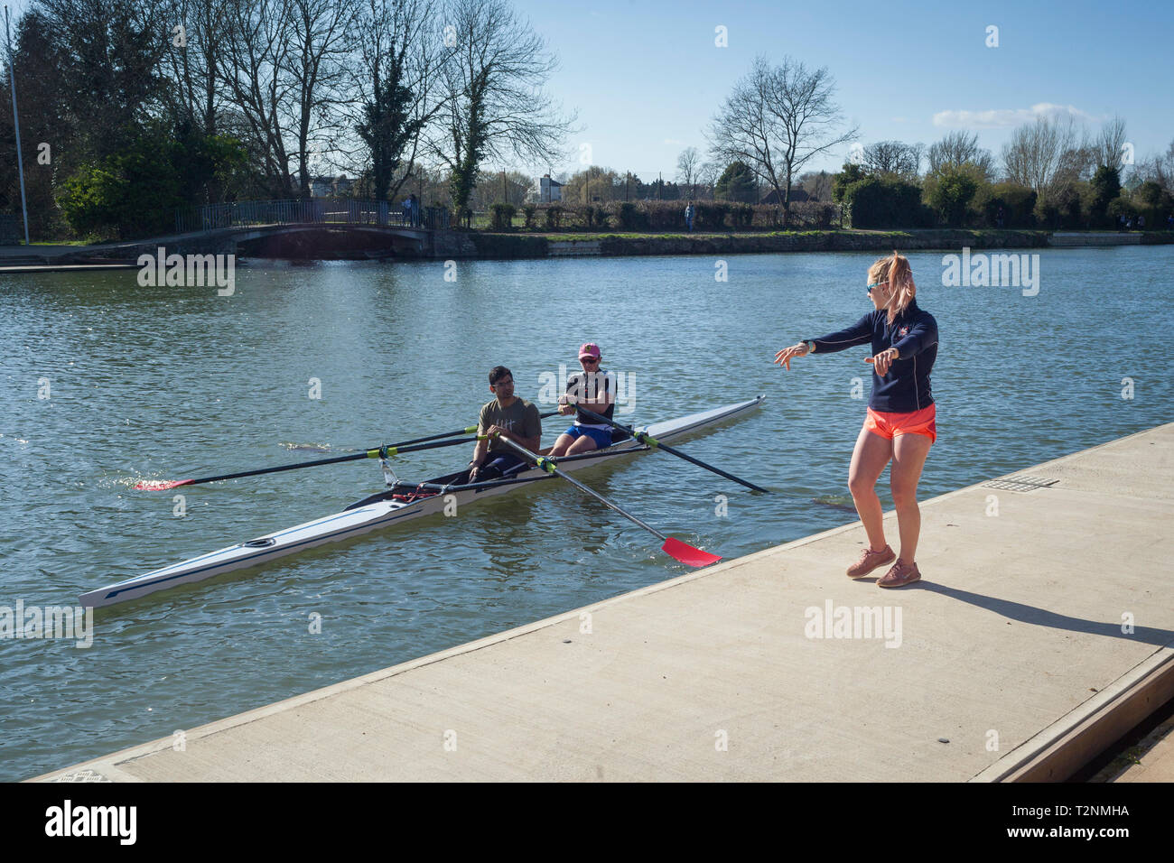 A female rowing coach and a men's double sculls crew on the River ...