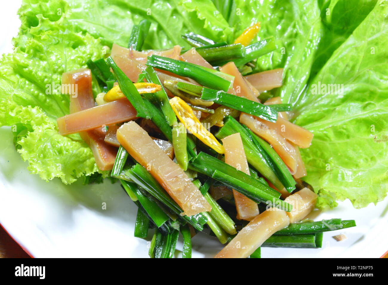 stir fried pickled crispy squid with garlic chives and lettuce on plate ...