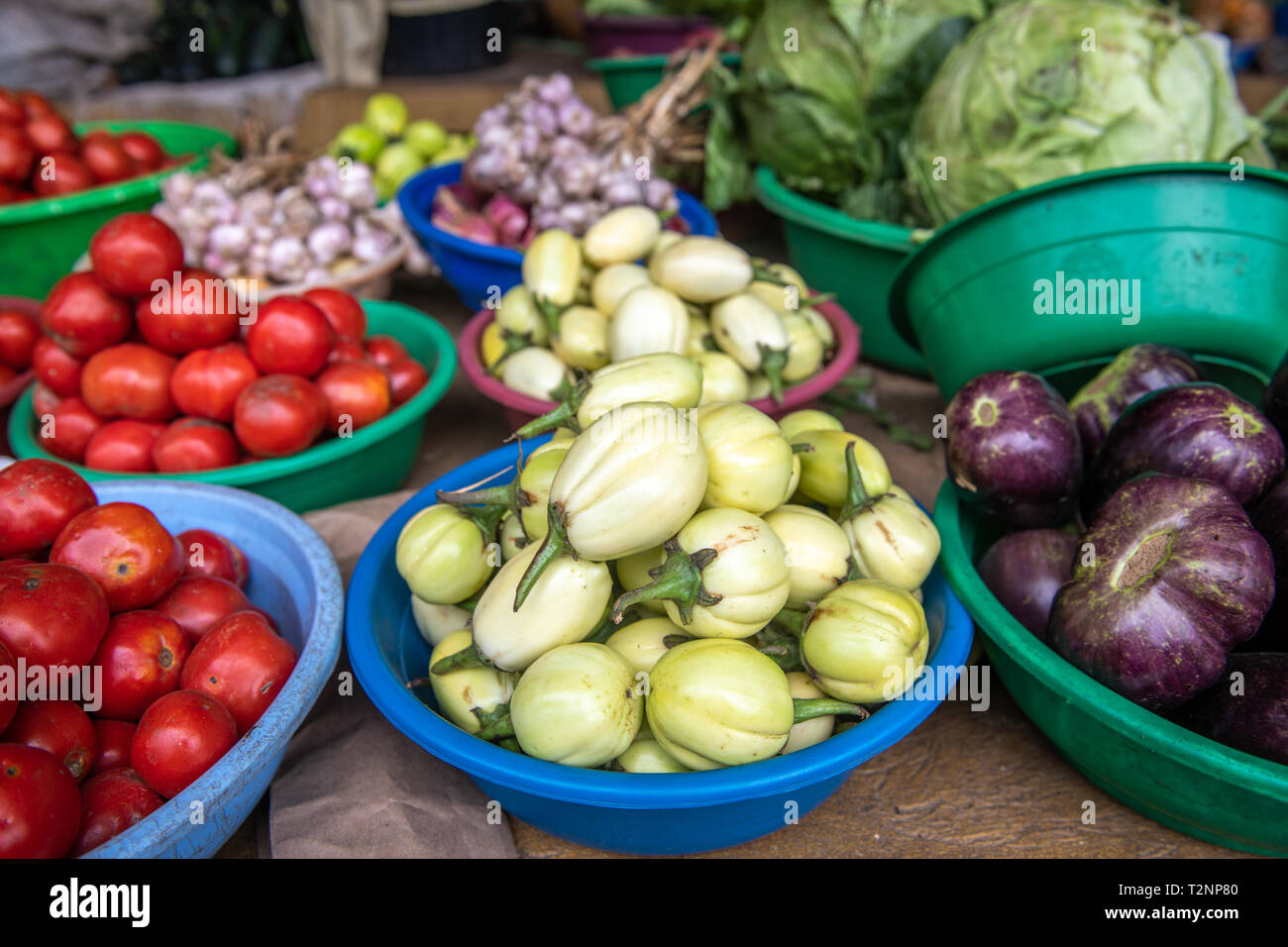 Plastic bowls full of eggplants and tomatoes at outdoor market, Rwanda ...
