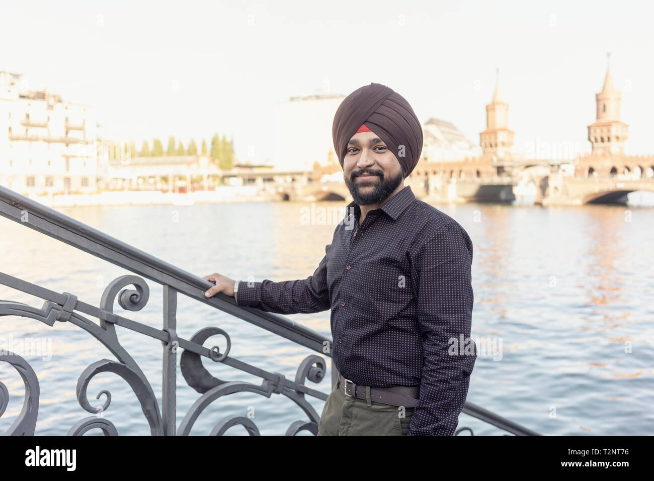Indian man exploring city, river in background, Berlin, Germany Stock ...