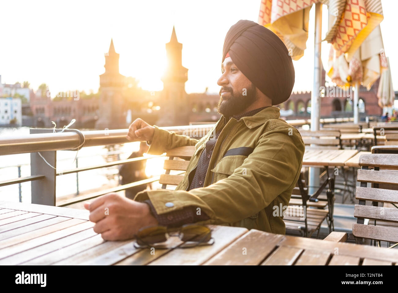 Indian man exploring city, river in background, Berlin, Germany Stock ...