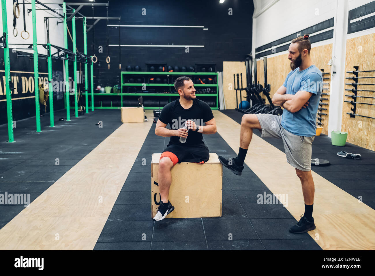 Personal trainer and man with disability enjoying conversation in gym ...