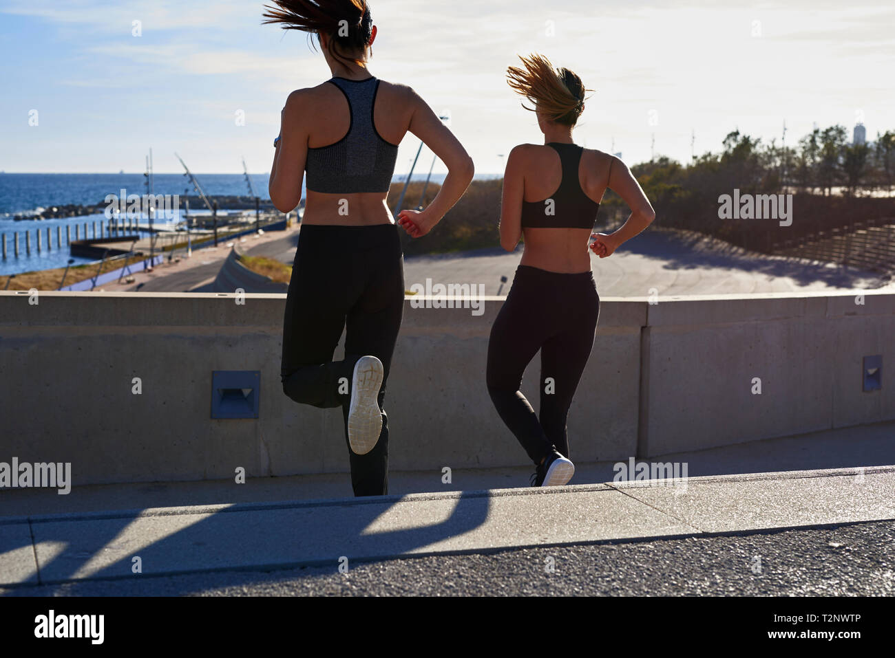 Friends jogging down steps in sports stadium Stock Photo - Alamy