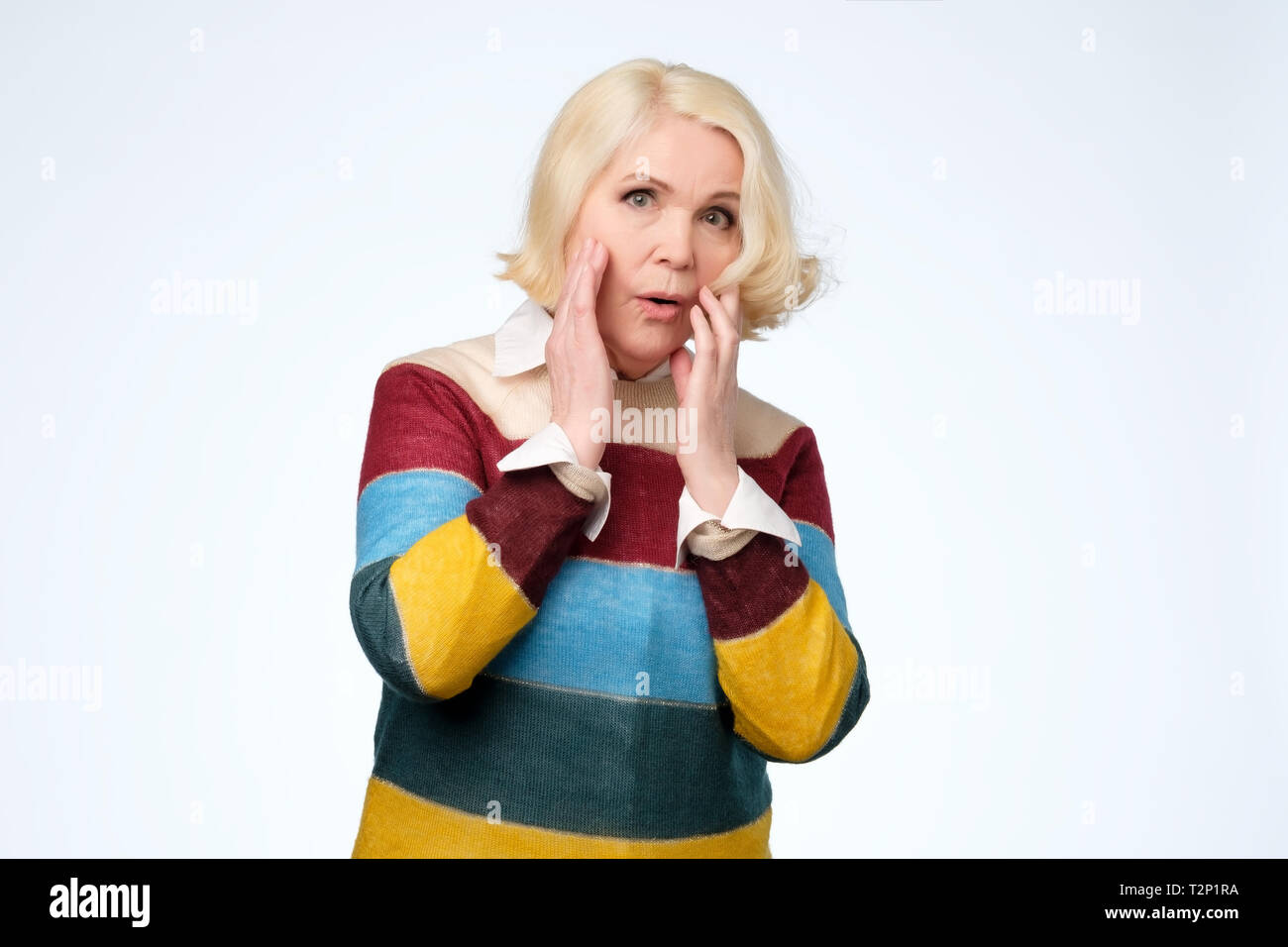 Shocked And Impressed Senior Blonde Woman Saying Wow Touching Face And