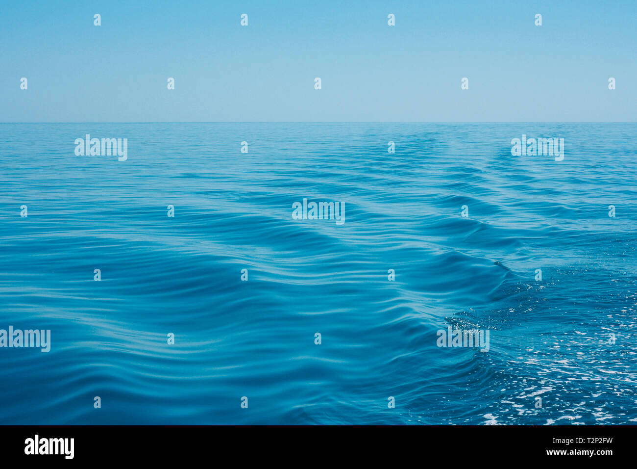Vivid natural blue sea waves boat trail background Stock Photo - Alamy