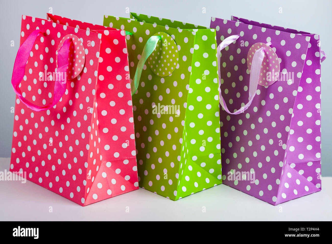 Three multi-colored shopping bags close-up Stock Photo - Alamy