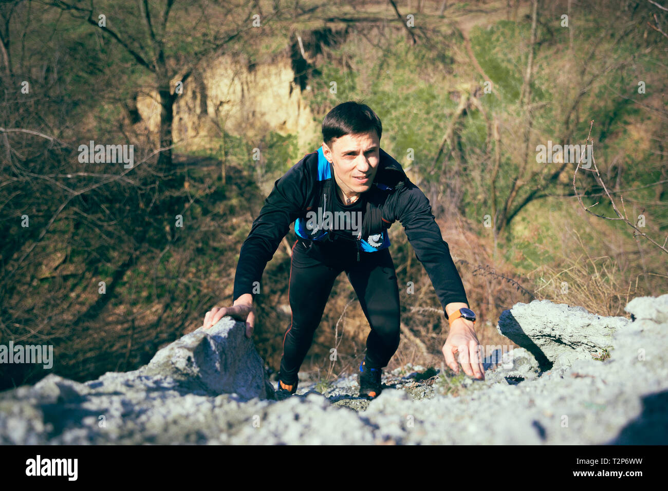 Springtime and jogging. Young man running at forest. Athlete crossing ...