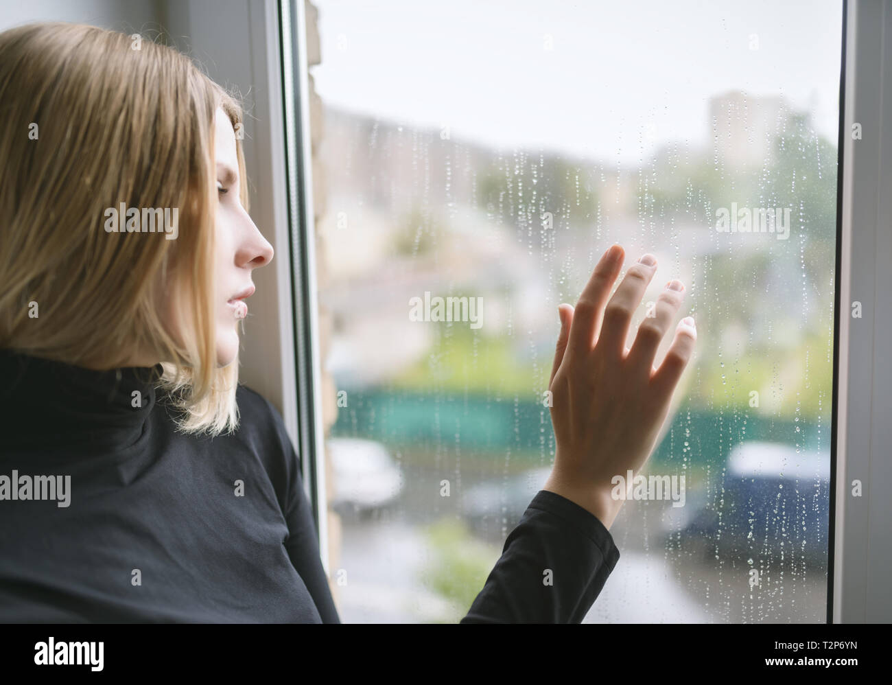 Sad woman looking through the glass window with a rain drops Stock ...