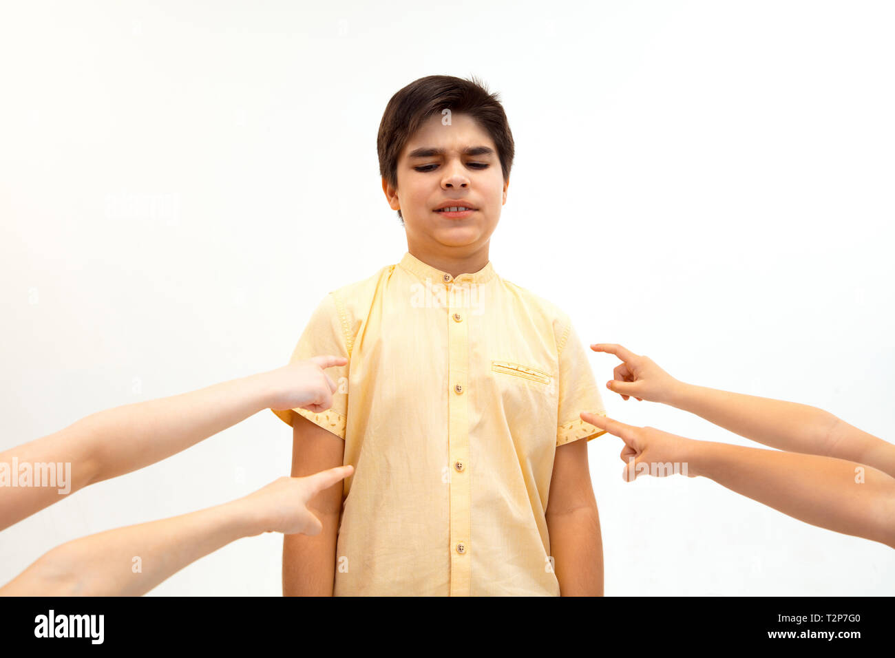 Little boy standing alone and suffering an act of bullying while ...