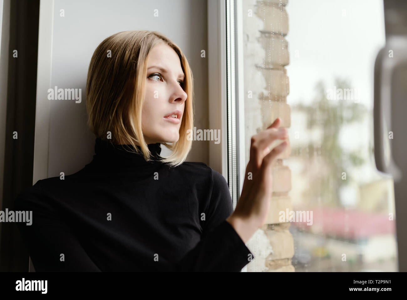 Sad woman looking through the glass window with a rain drops Stock ...