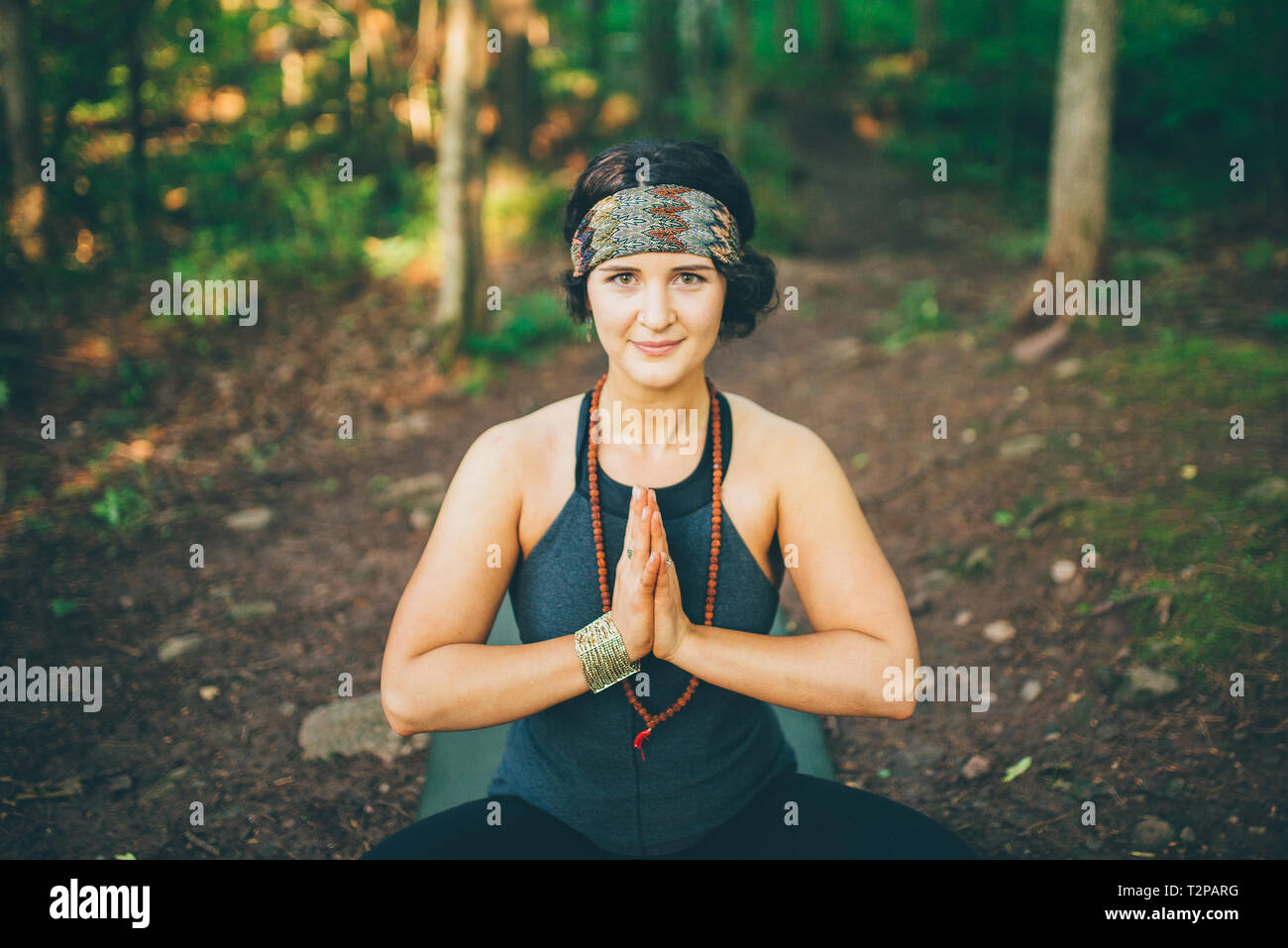 Woman doing prayer pose in forest Stock Photo - Alamy