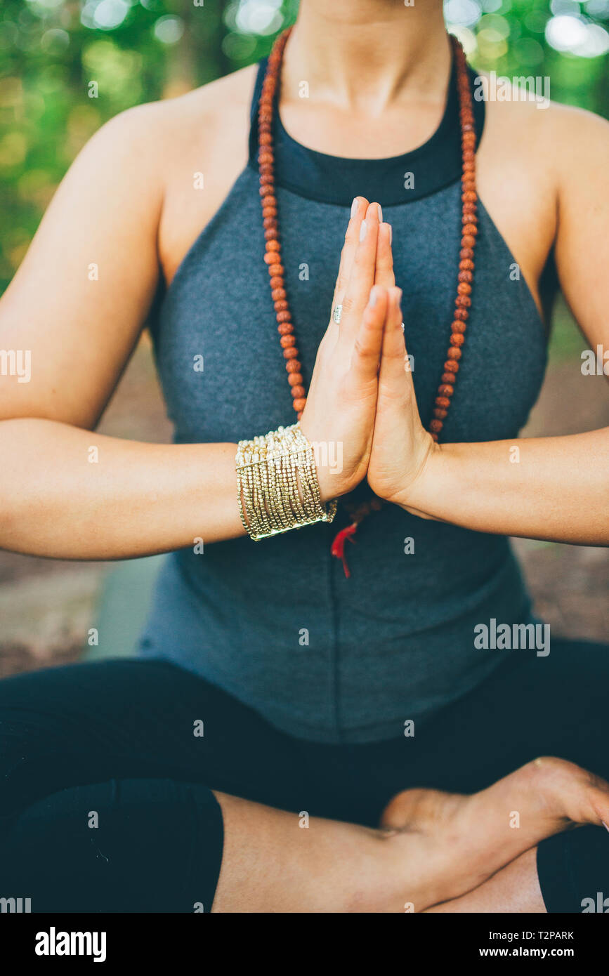 Woman doing prayer pose in forest Stock Photo - Alamy