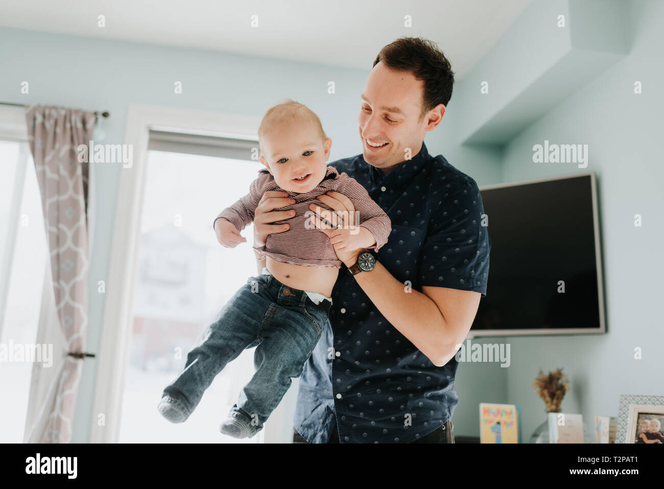 Father playing with baby son in living room Stock Photo - Alamy