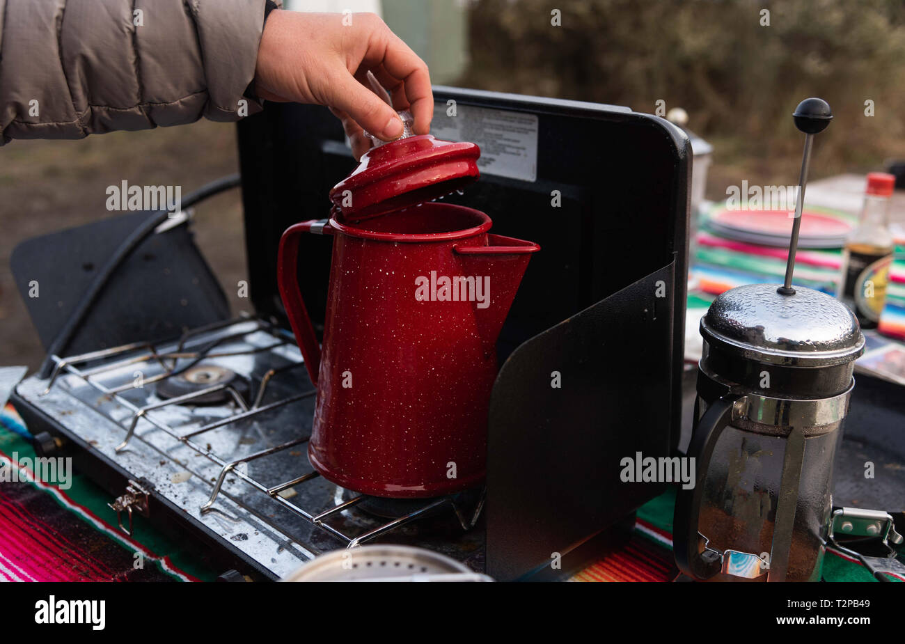 Camper checking kettle on camping stove Stock Photo - Alamy