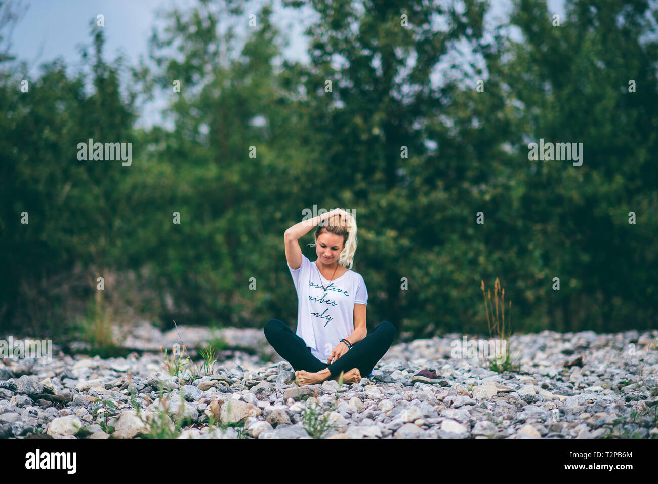 Woman stretching on bed of stones, Banff, Canada Stock Photo - Alamy