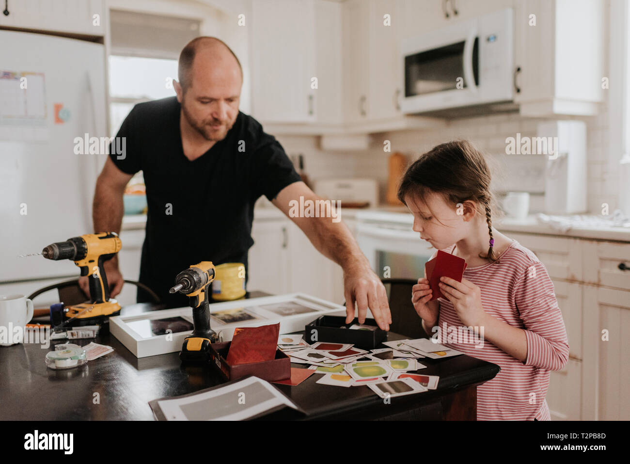 Girl helping father arrange cards into box in kitchen Stock Photo - Alamy