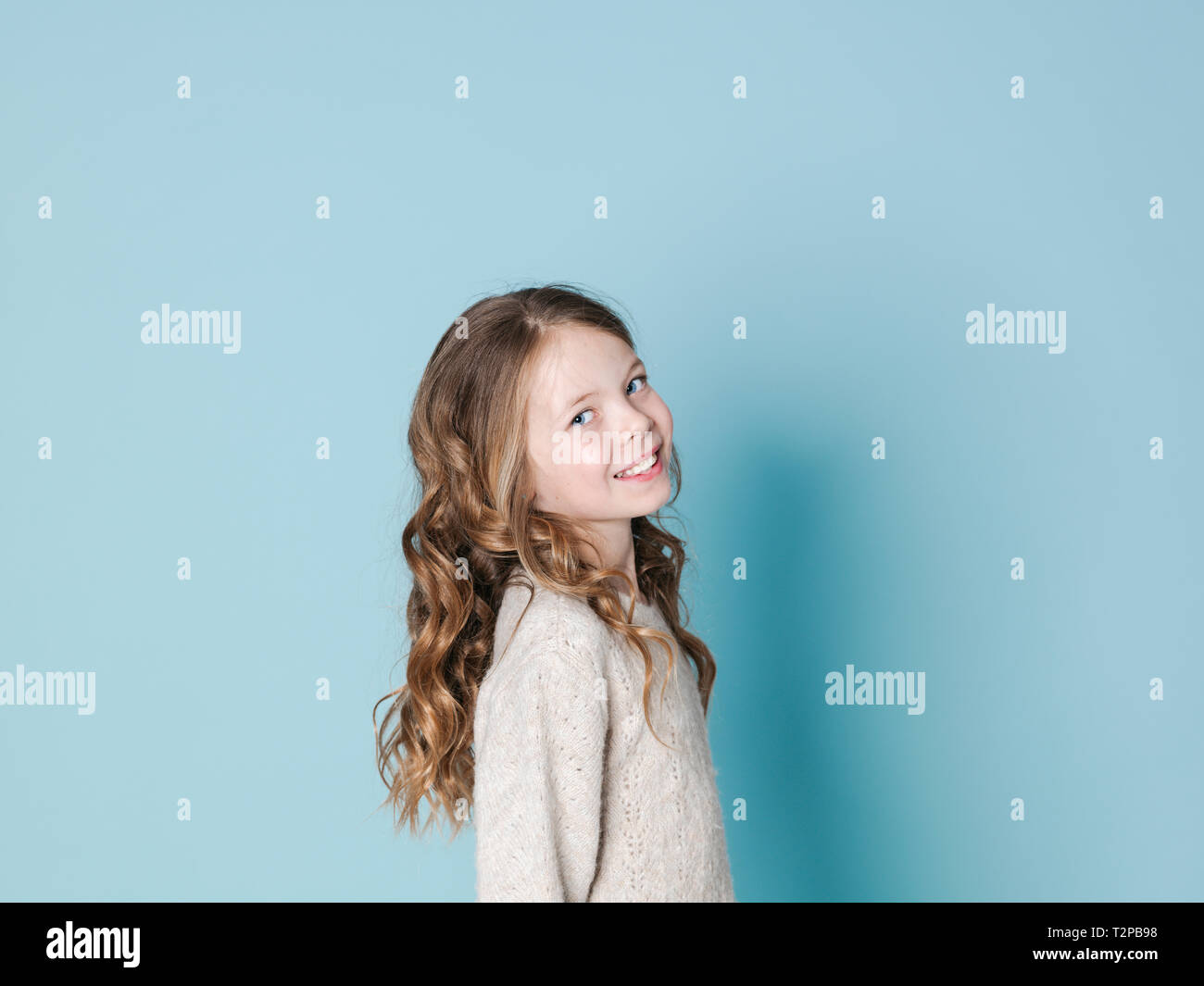 pretty and cool 9 year old girl with brown wool sweater posing in front ...