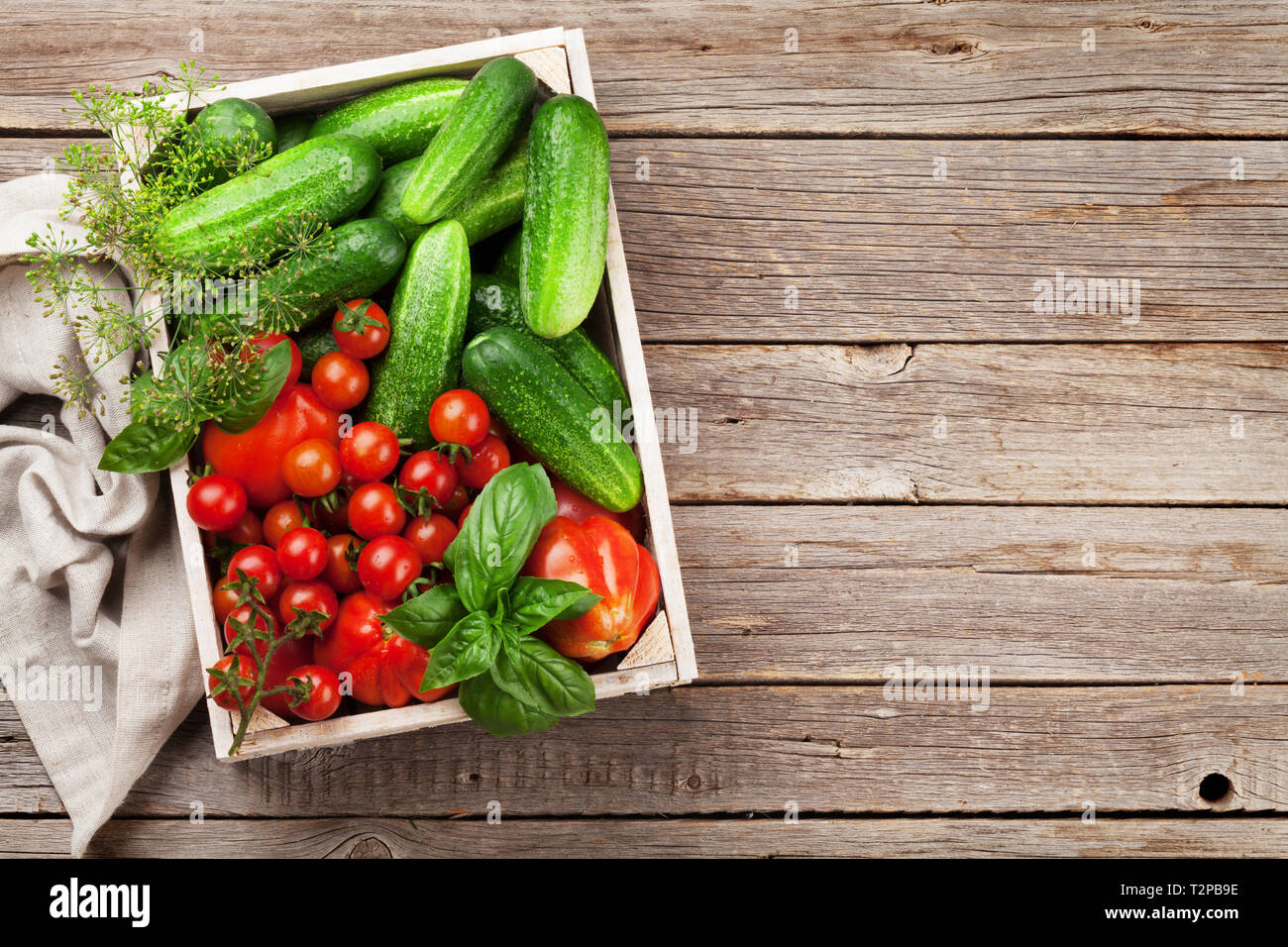 Fresh garden tomatoes and cucumbers on cooking table. Top view with ...