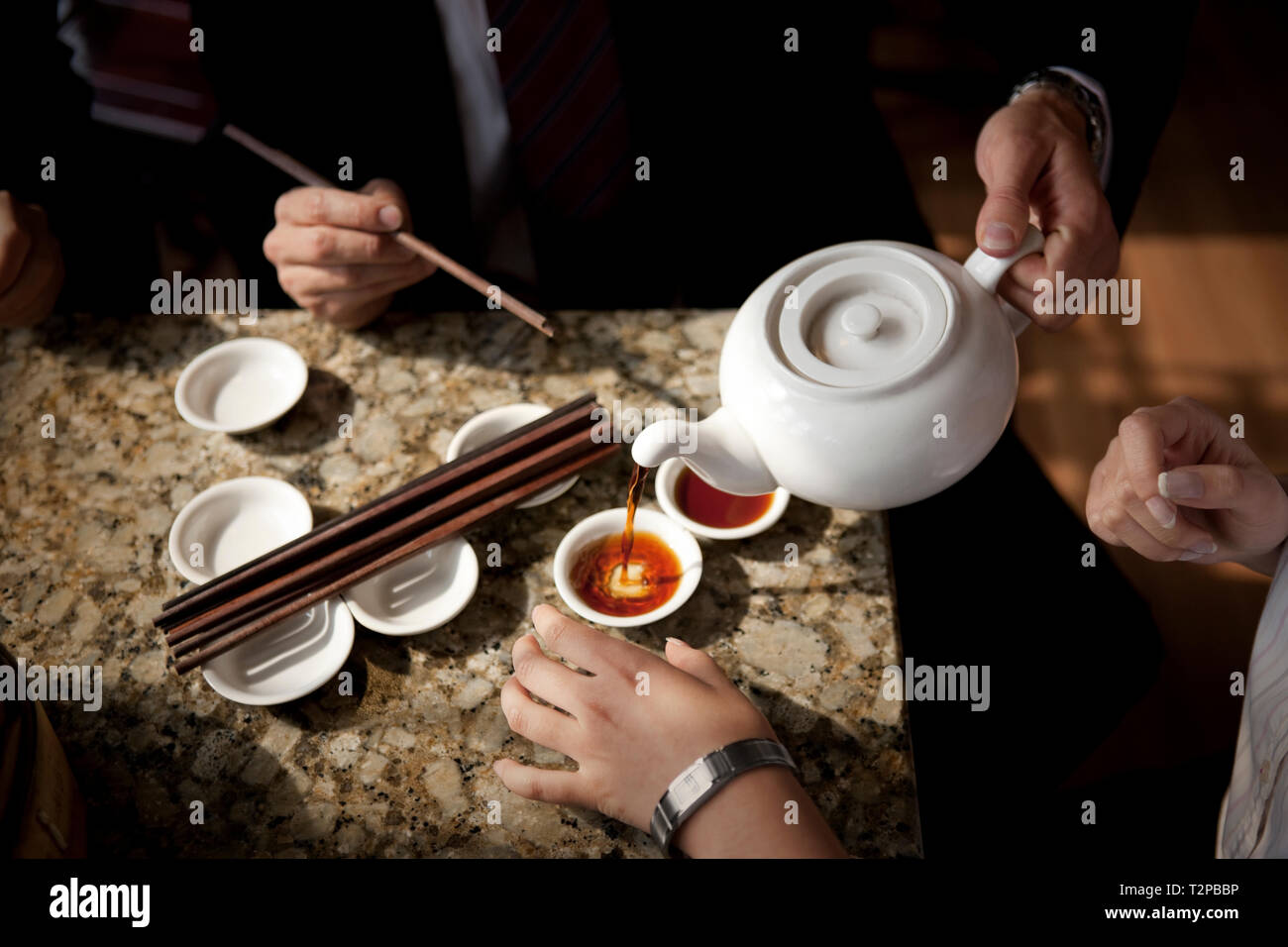 Tea being poured at a table inside a traditional restaurant Stock Photo ...