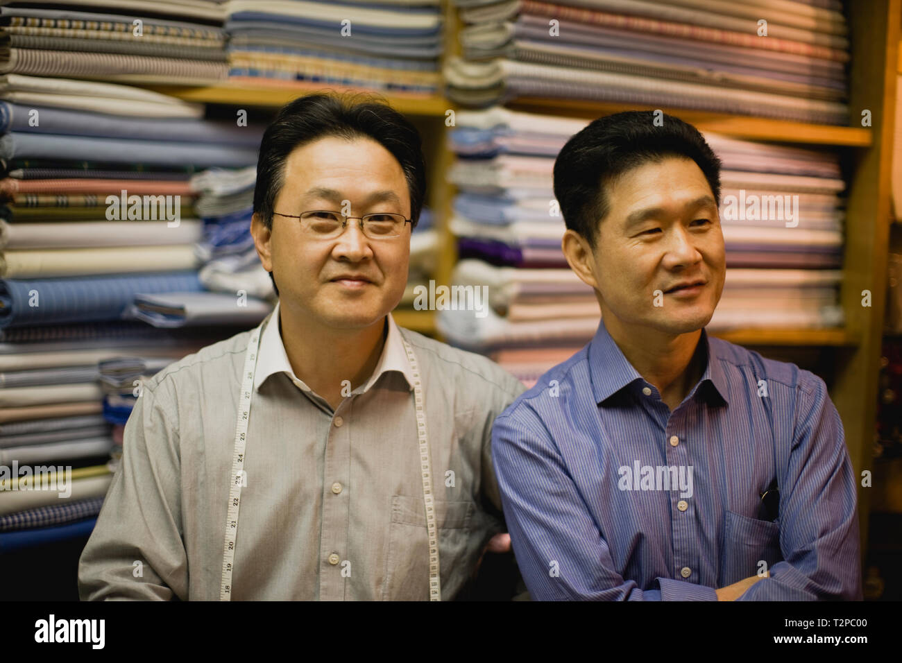 Portrait of two male tailors inside a clothing store Stock Photo - Alamy