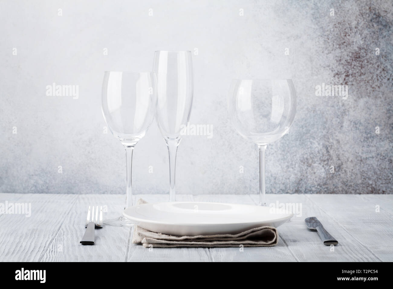 Dinner plate setting with cutlery and glasses. View with copy space ...