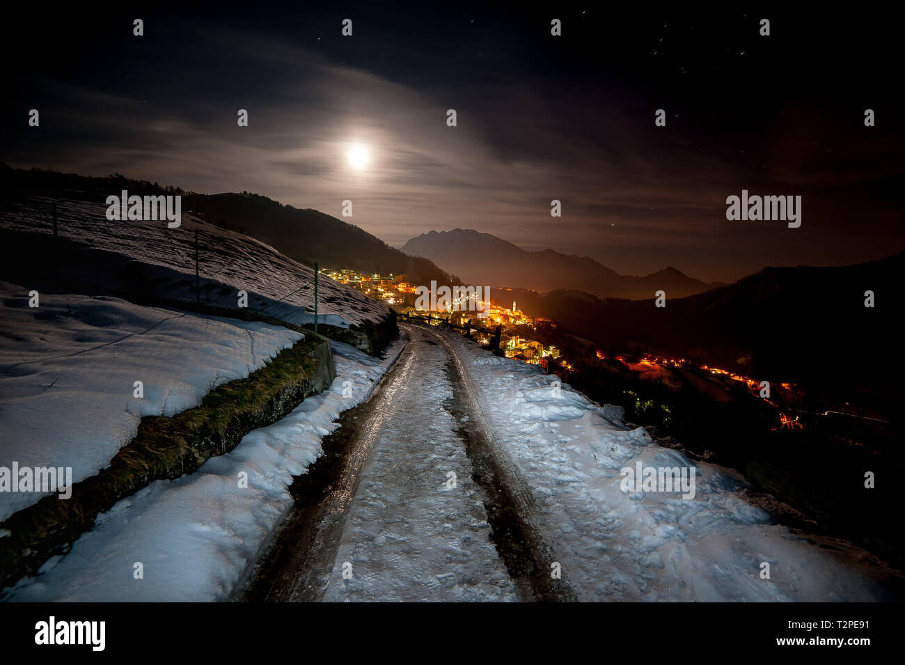 snowy mountain village at night with the moon Stock Photo - Alamy