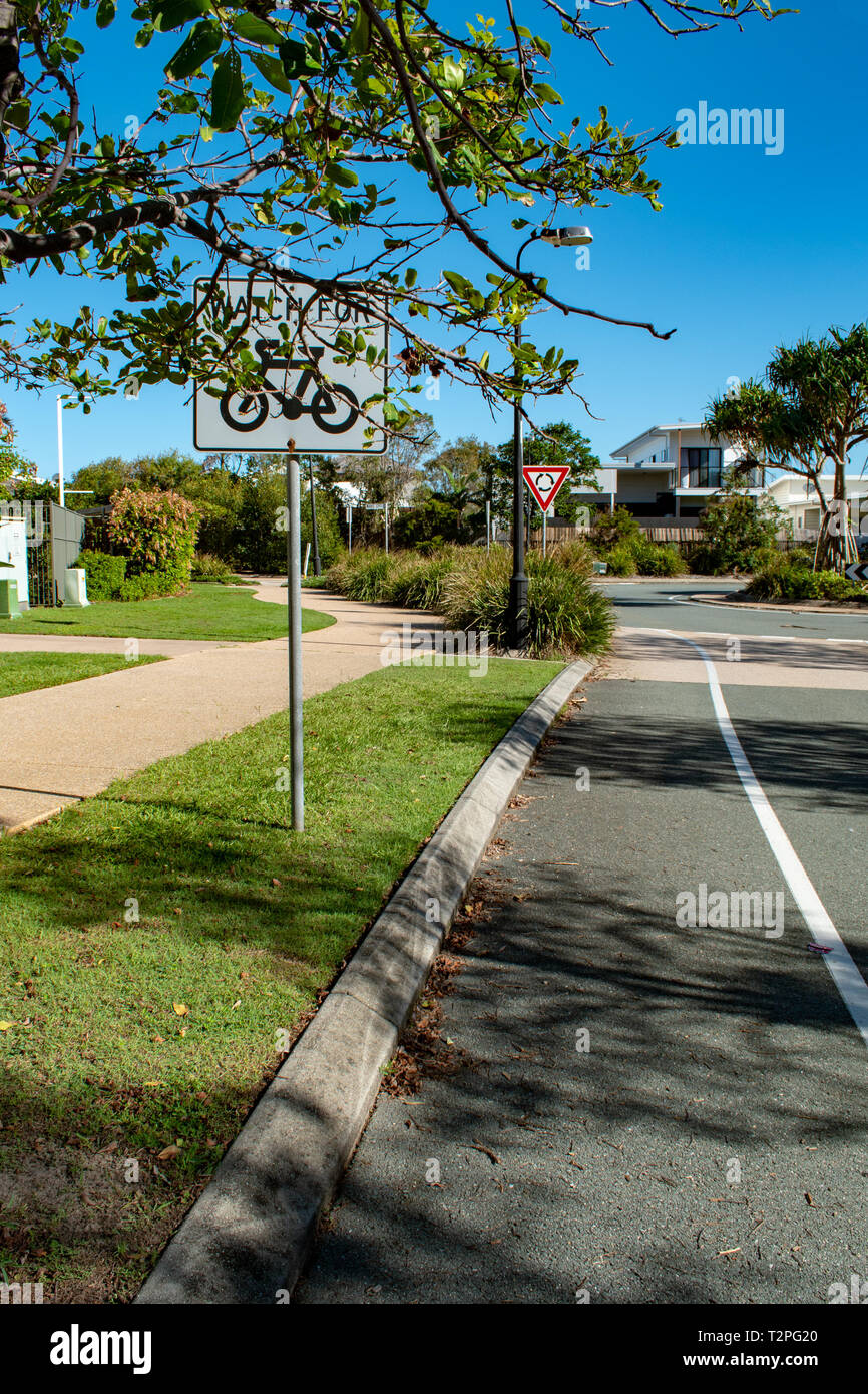 A badly placed road sign behind a tree potentially causing a safety ...